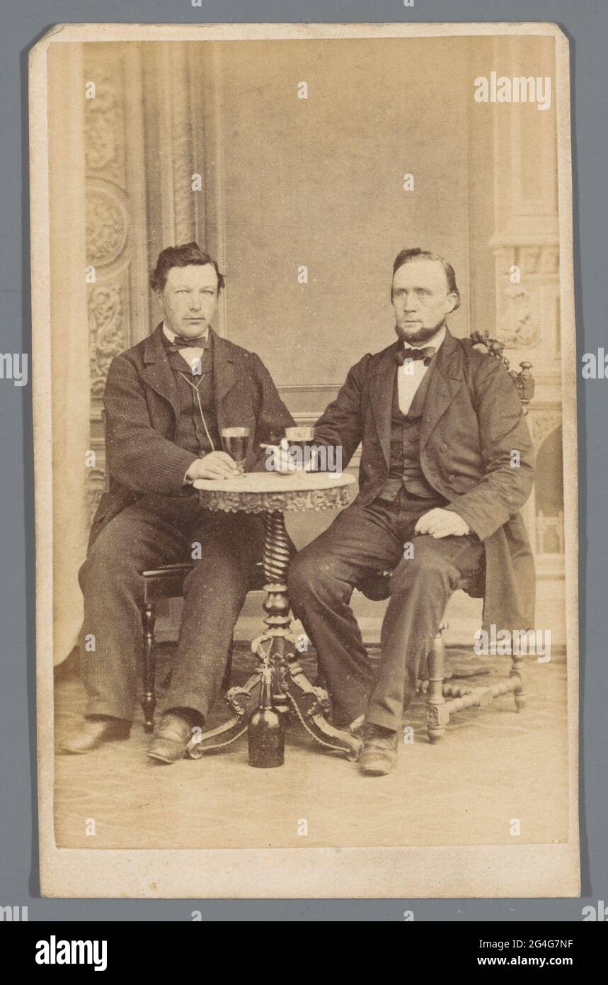 Two men at table with glass drink Stock Photo - Alamy