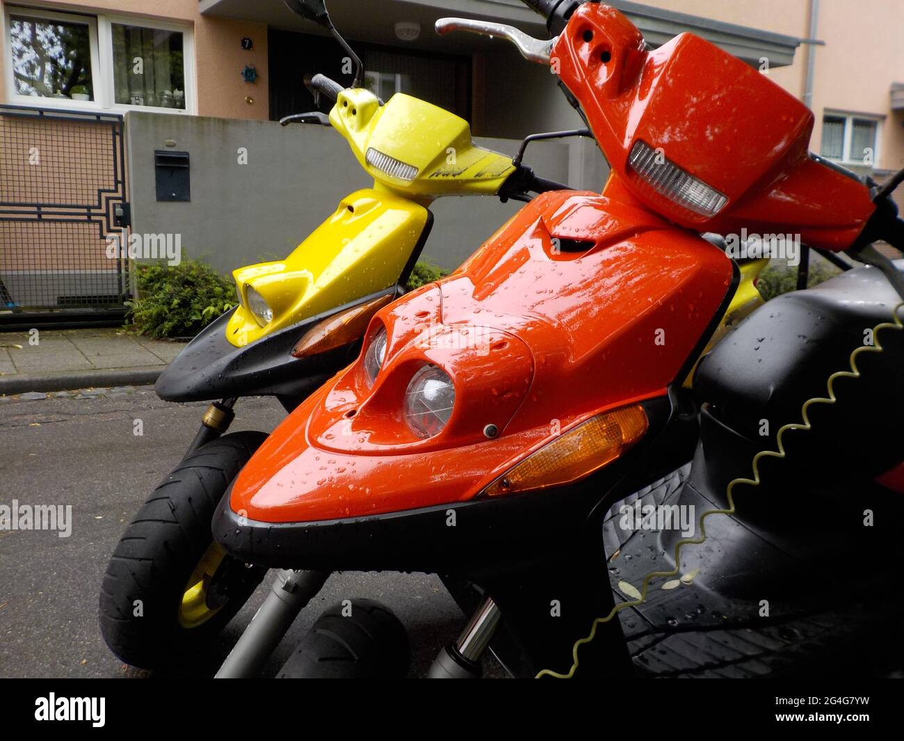 The yellow and red platic front skirts of two motor scooters with ...