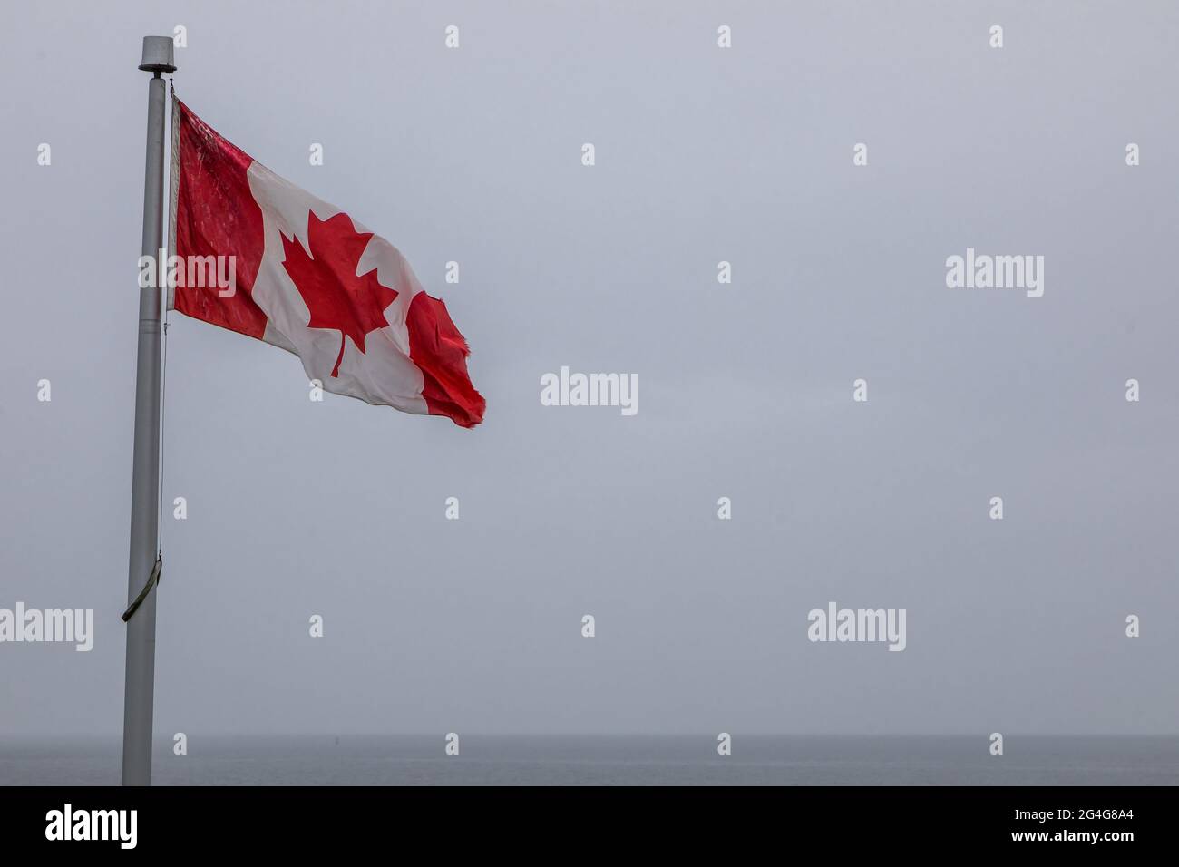 Canadian Flag flying on a rainy, cloudy day Stock Photo - Alamy
