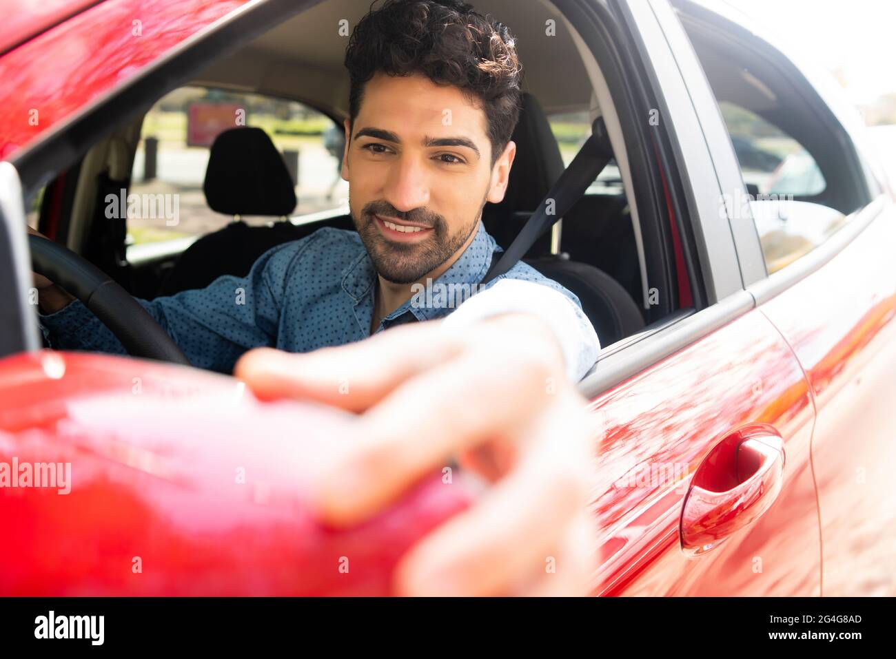 Man moving rear view wing mirror in car Stock Photo - Alamy