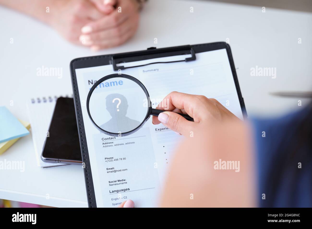 Employer looking at worker resume with magnifying glass closeup Stock ...