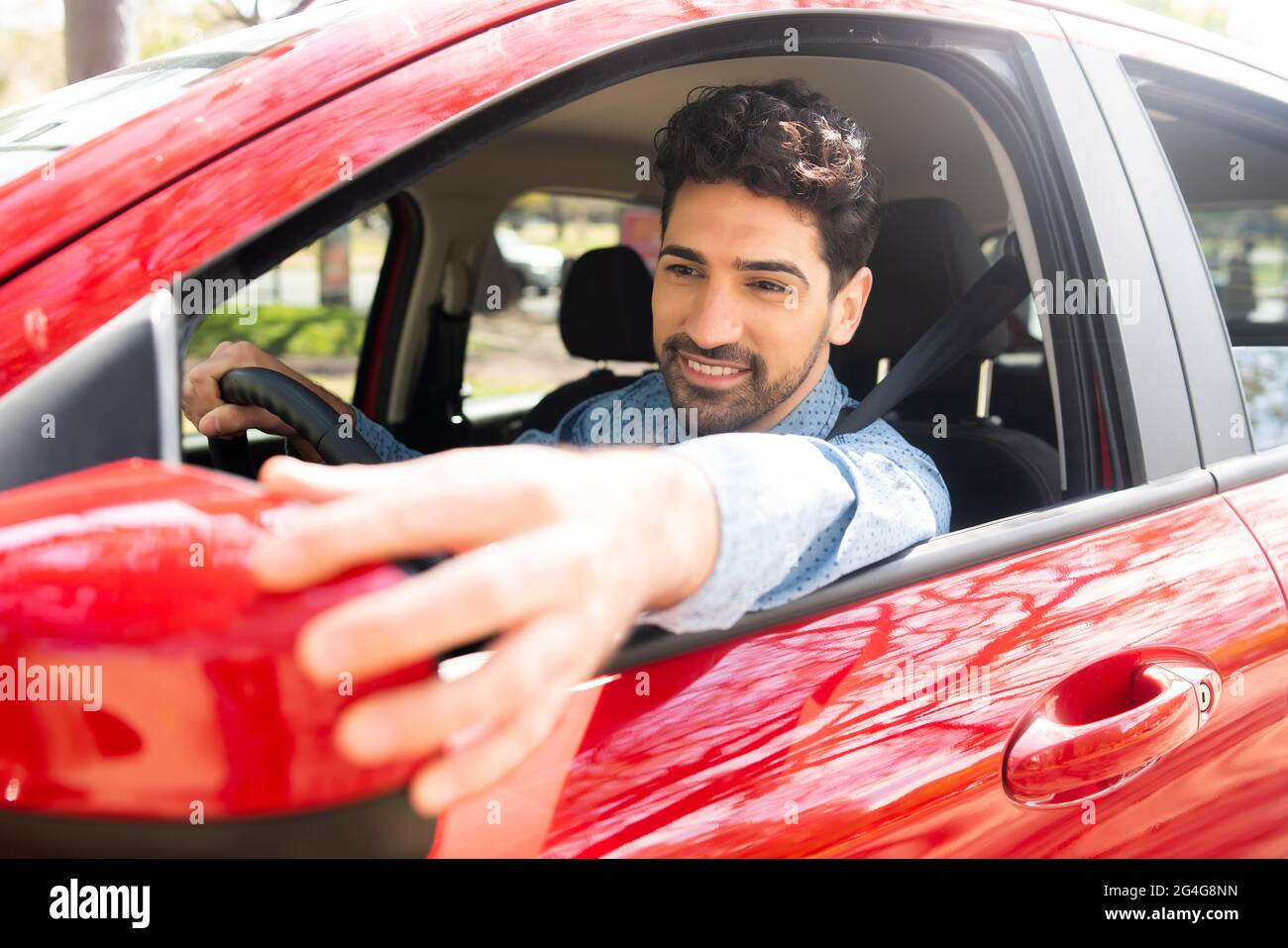 Man moving rear view wing mirror in car Stock Photo - Alamy