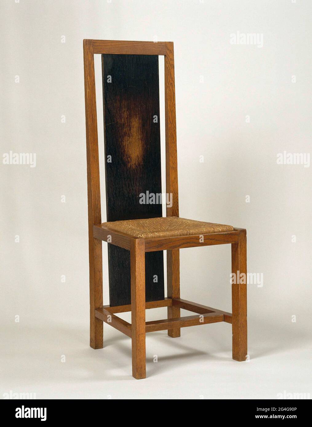 . Oak chair resting on four rectangular legs. The legs are ...
