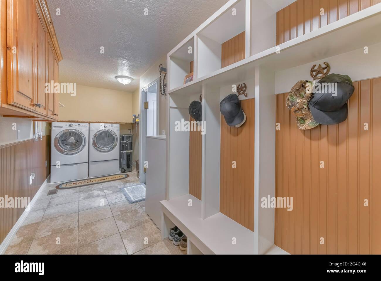 Tiled floor laundry room with individual cabinets and two washing ...