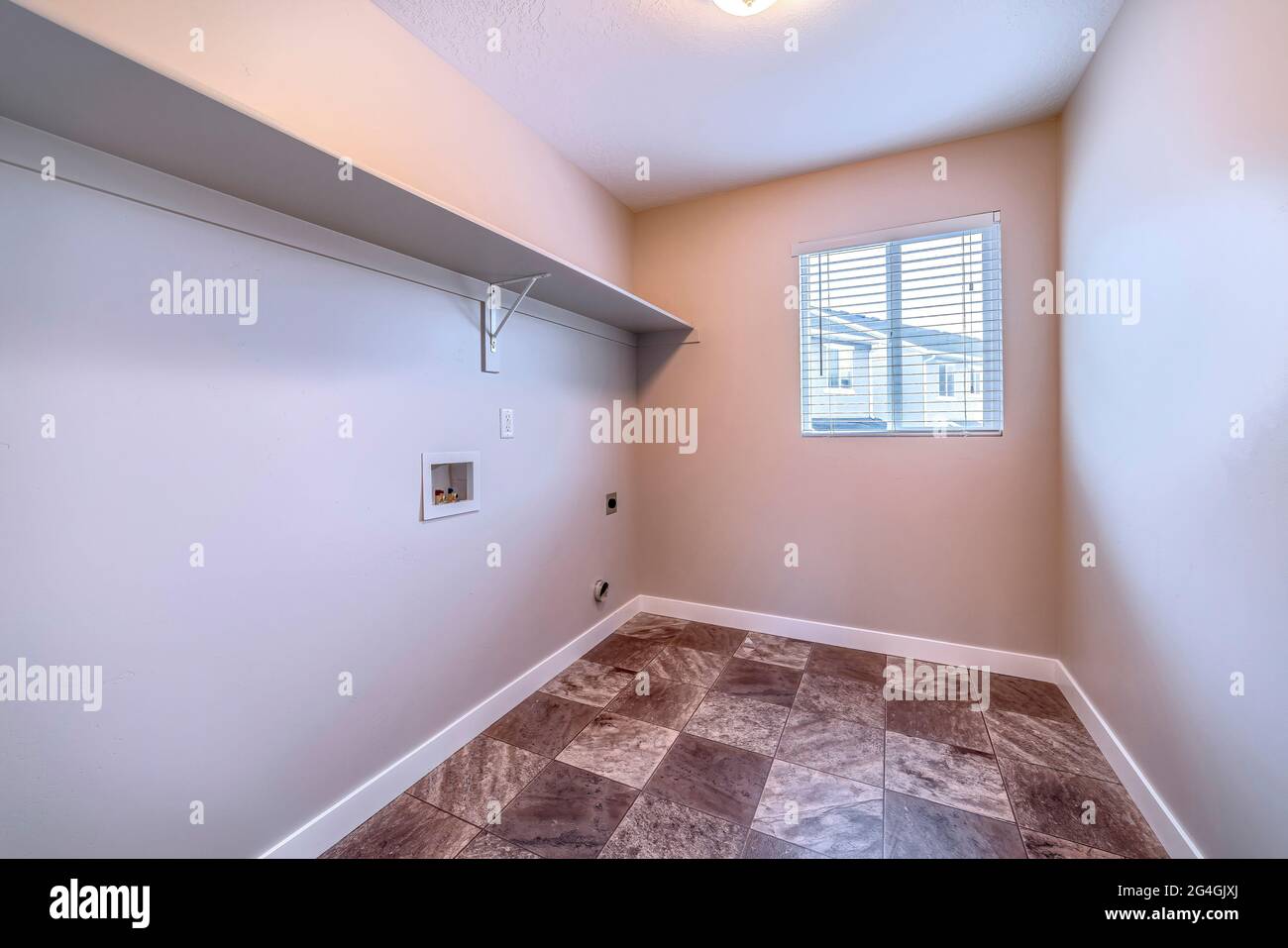 Empty tiled floor room with a window and a wooden rack on the wall ...