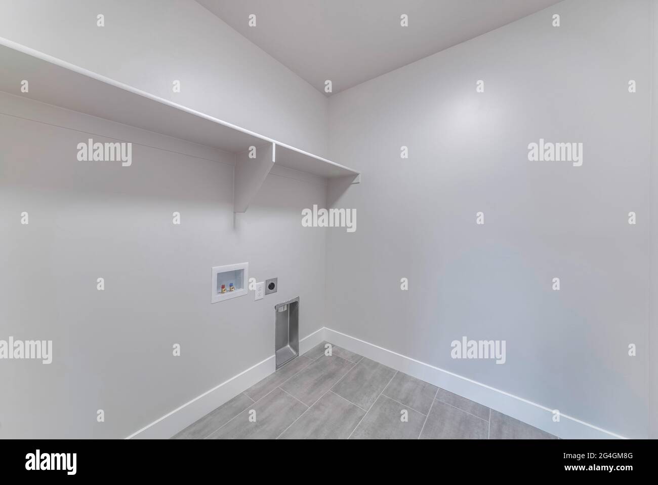 A renovated empty room with a long wooden shelf on a white wall Stock ...