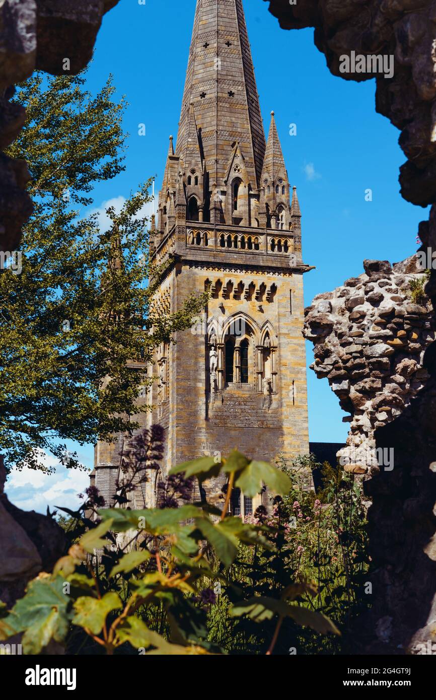 Ancient catholic cathedral tower in the frame of the ruins and green ...