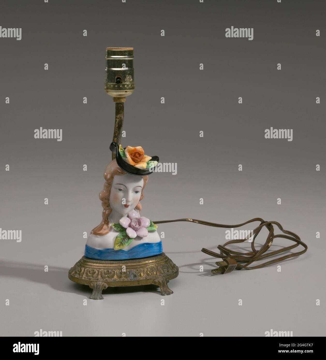 A metal lamp base with a painted porcelain decoration of an English ...