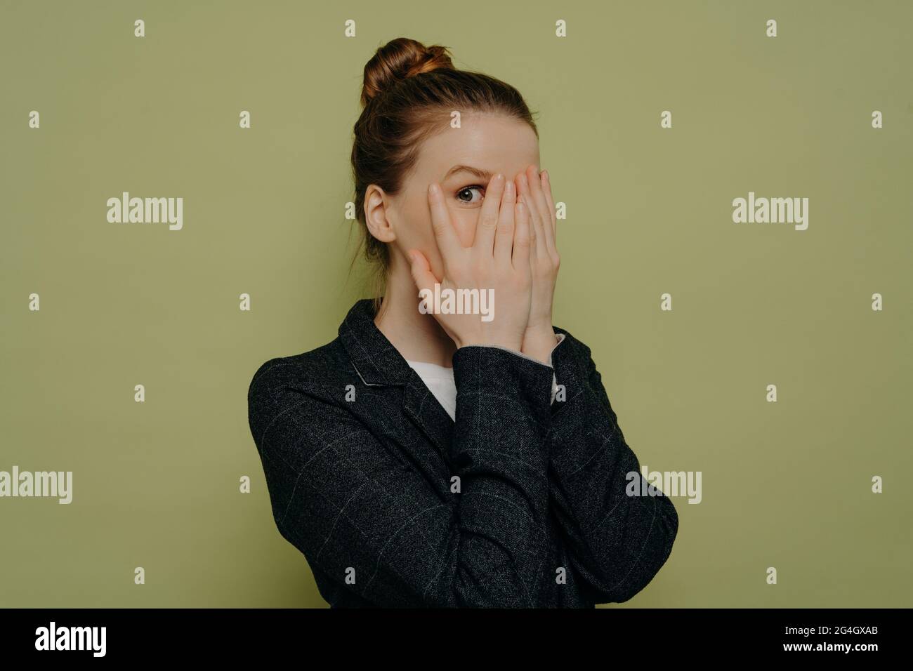 Young woman in formal wear closing face with hands Stock Photo - Alamy