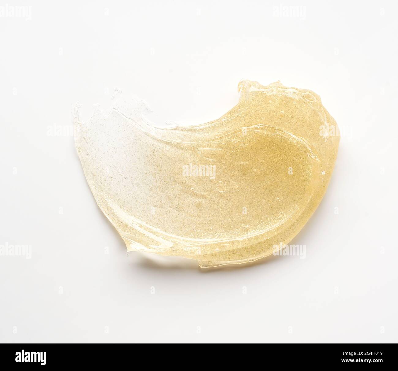 Transparent smear and texture of golden cosmetic gel on a white ...