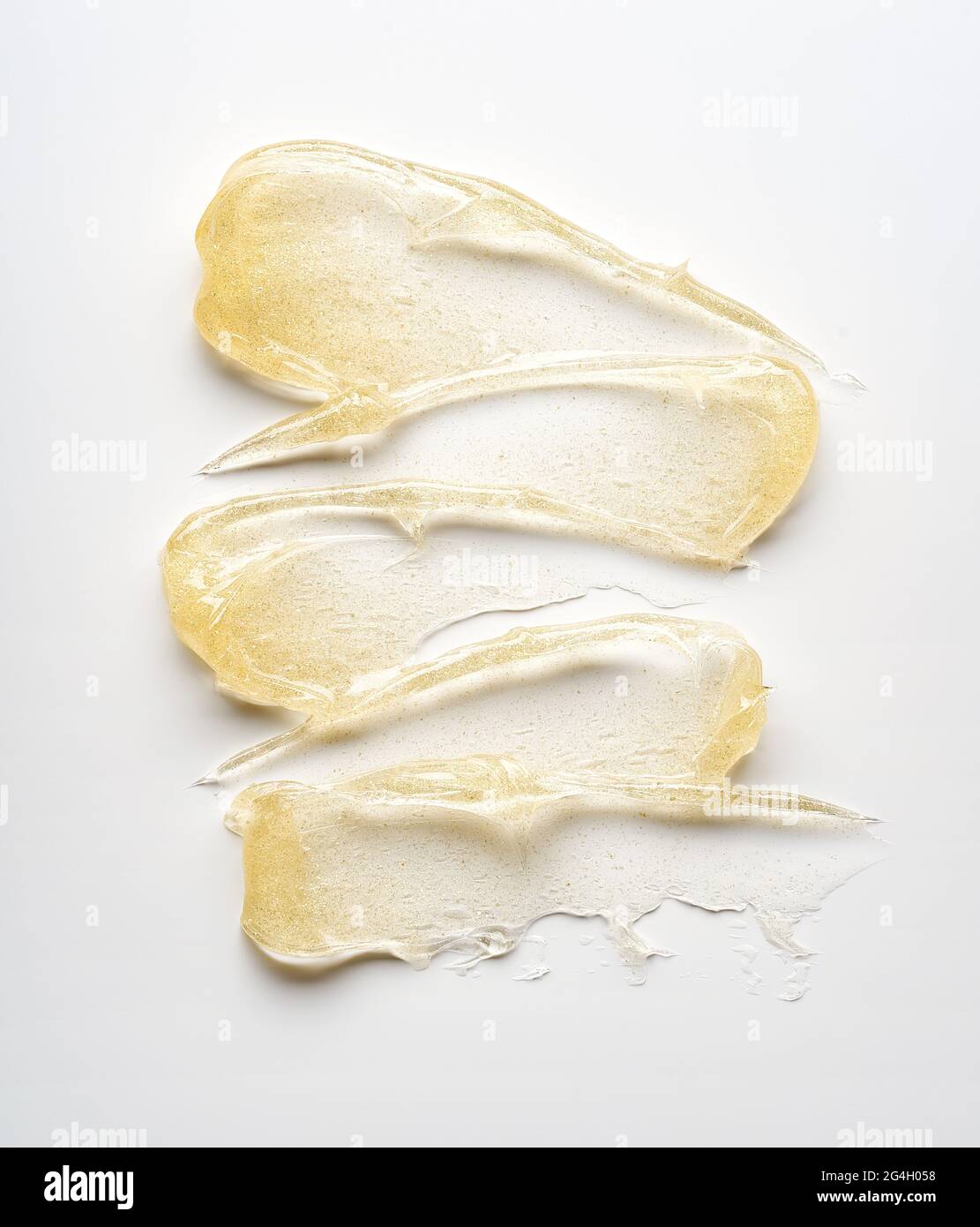 Transparent smear and texture of golden cosmetic gel on a white ...