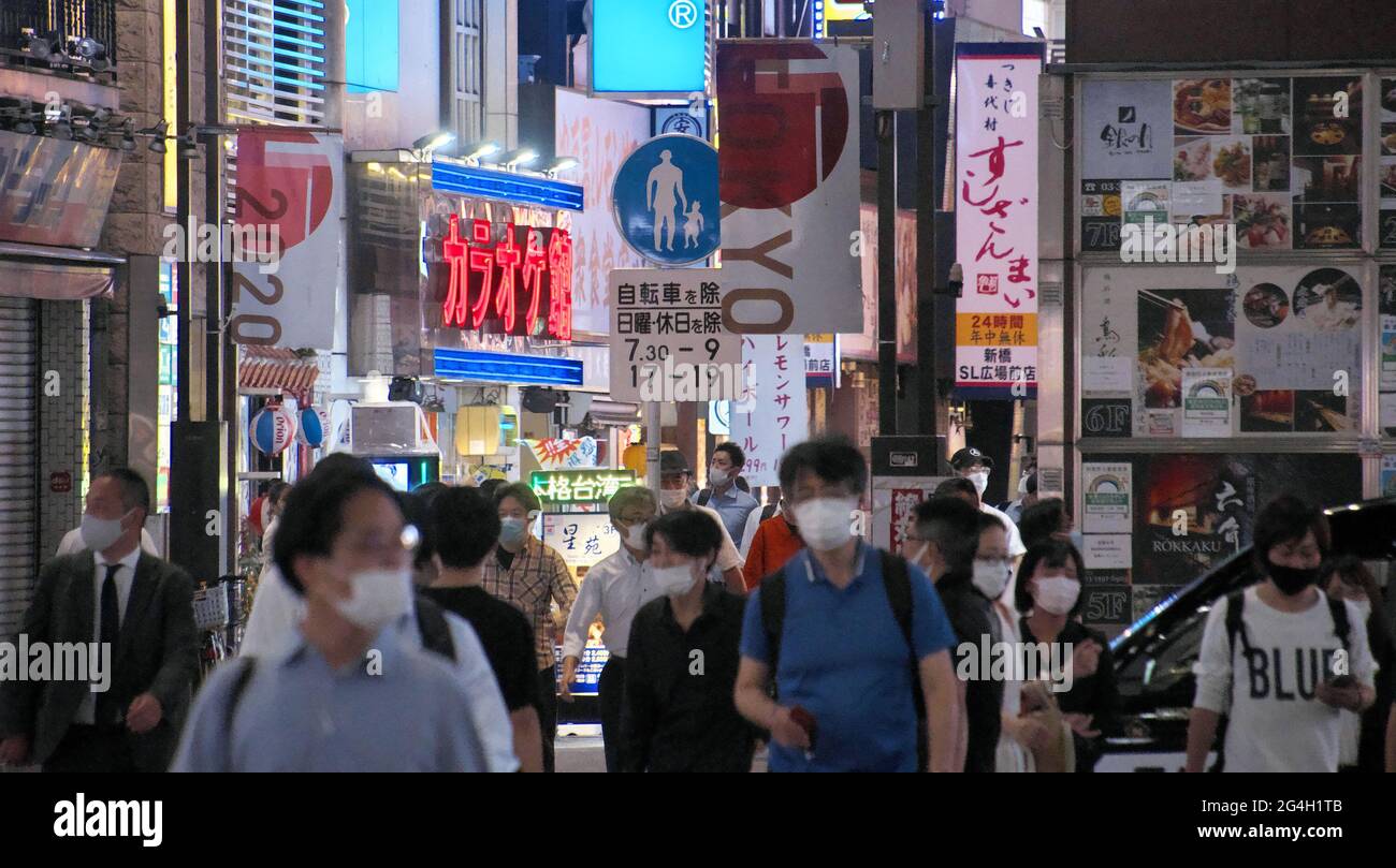Tokyo, Japan. 21st June, 2021. Pedestrians wearing face masks walk at ...