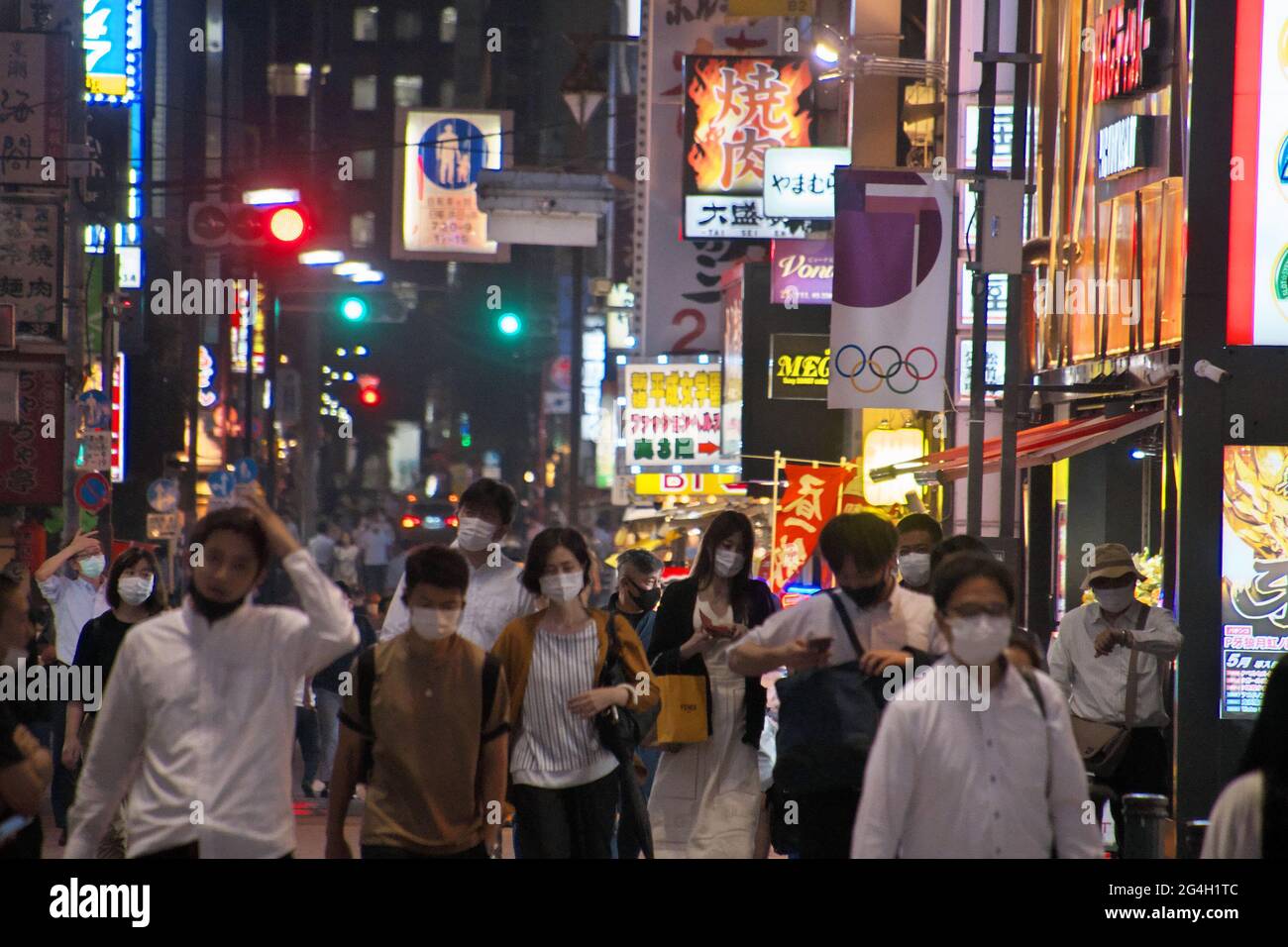 Tokyo, Japan. 21st June, 2021. Pedestrians wearing face masks walk at ...
