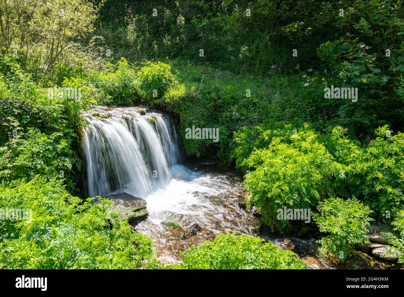 Long exposure of a waterfall flowing onto Lee Abbey Beach in Devon ...