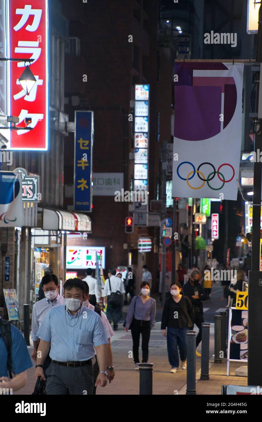 Tokyo, Japan. 21st June, 2021. Pedestrians wearing face masks walk in ...
