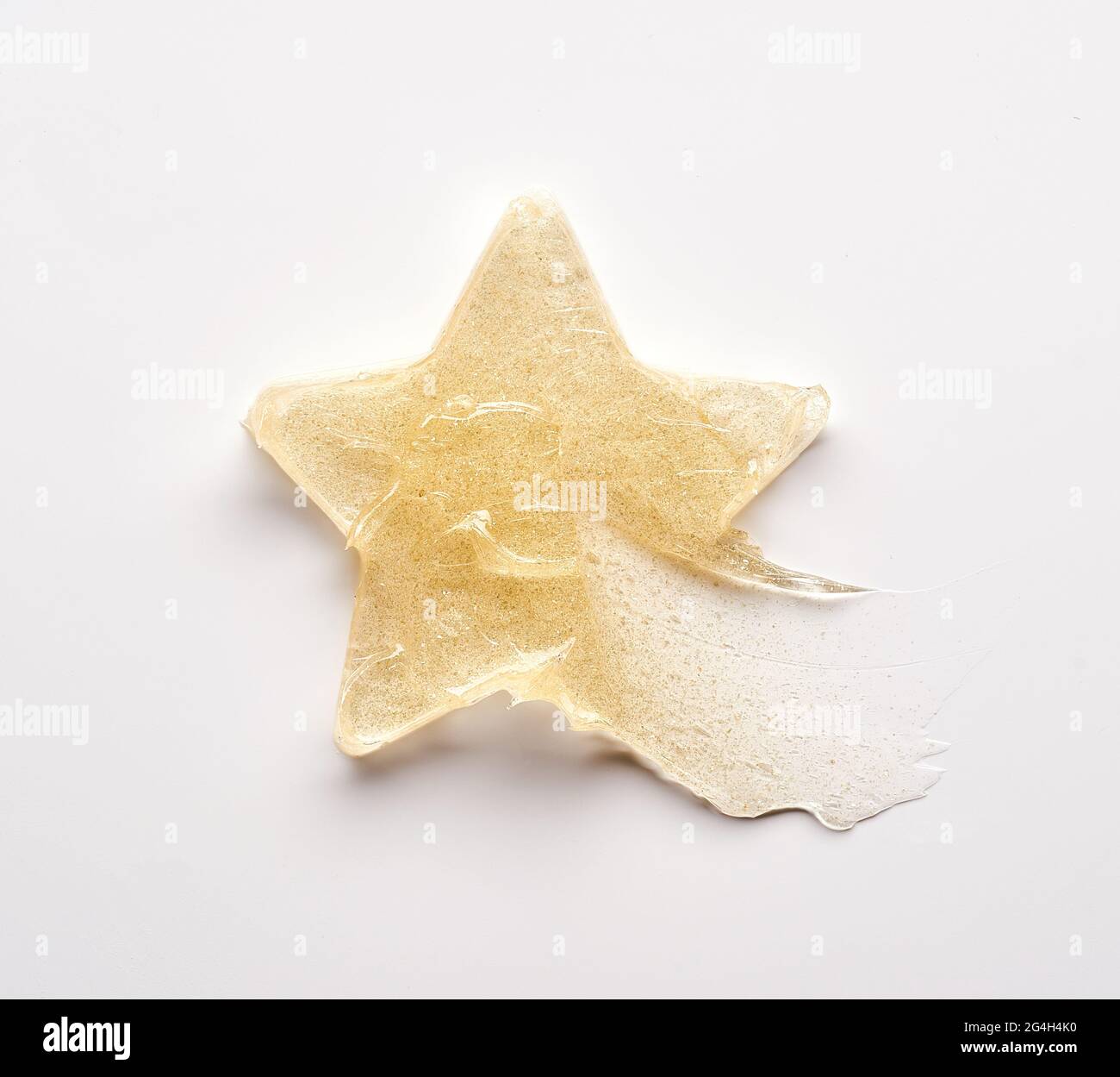 Transparent smear and texture of golden cosmetic gel on a white ...