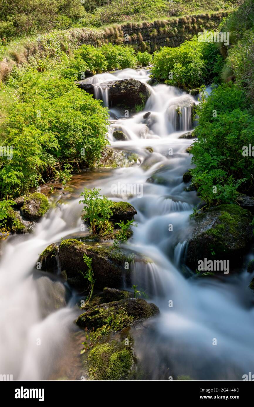Long exposure of a waterfall flowing onto Lee Abbey Beach in Devon ...