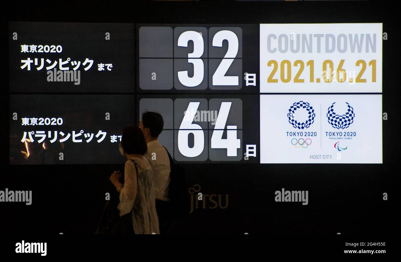 Tokyo, Japan. 21st June, 2021. Pedestrians walk past the countdown ...