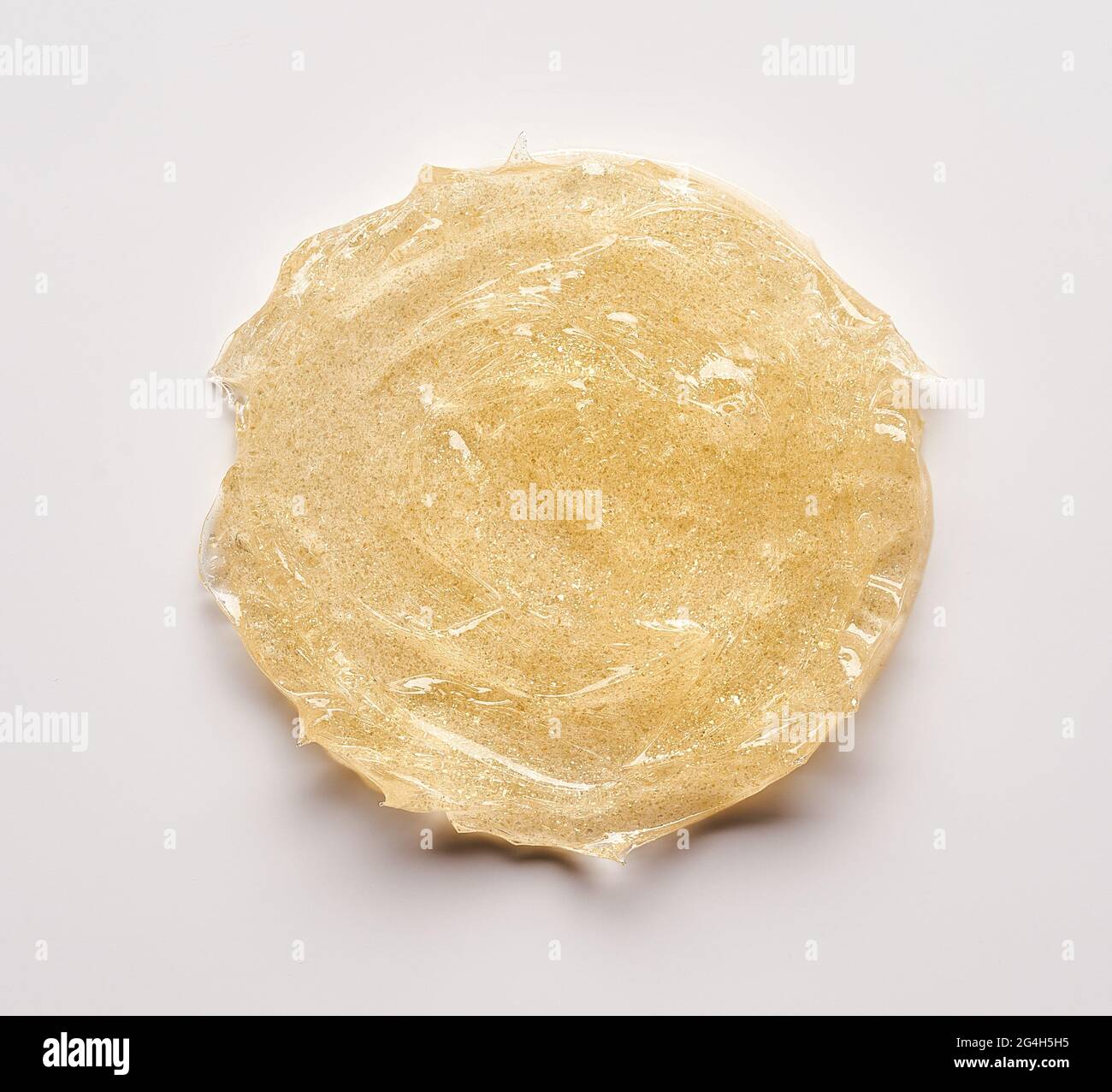 Transparent smear and texture of golden cosmetic gel on a white ...