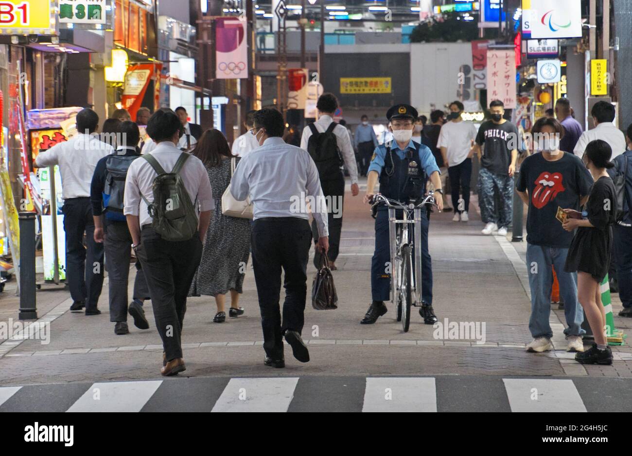 Tokyo, Japan. 21st June, 2021. Pedestrians wearing face masks walk in ...