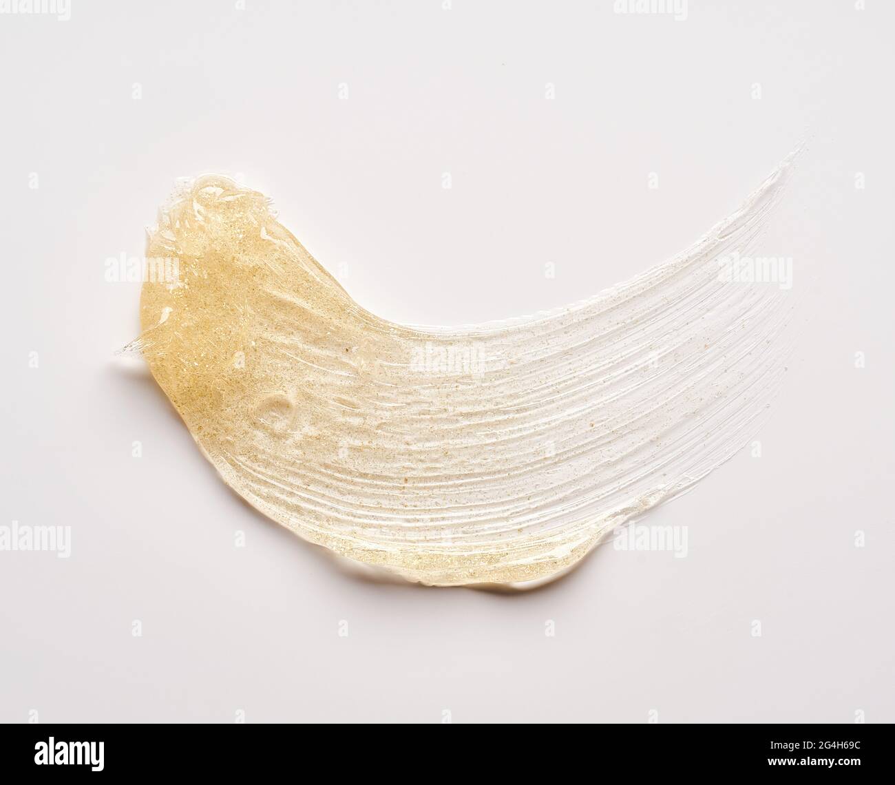 Transparent smear and texture of golden cosmetic gel on a white ...