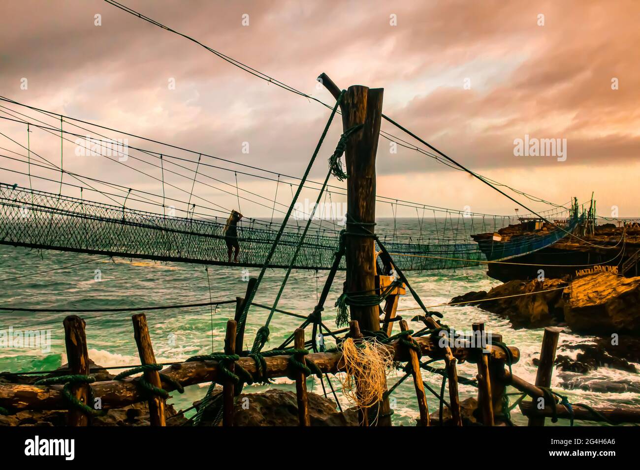 One man takes the challenge walking on a swinging rope foot bridge to a ...