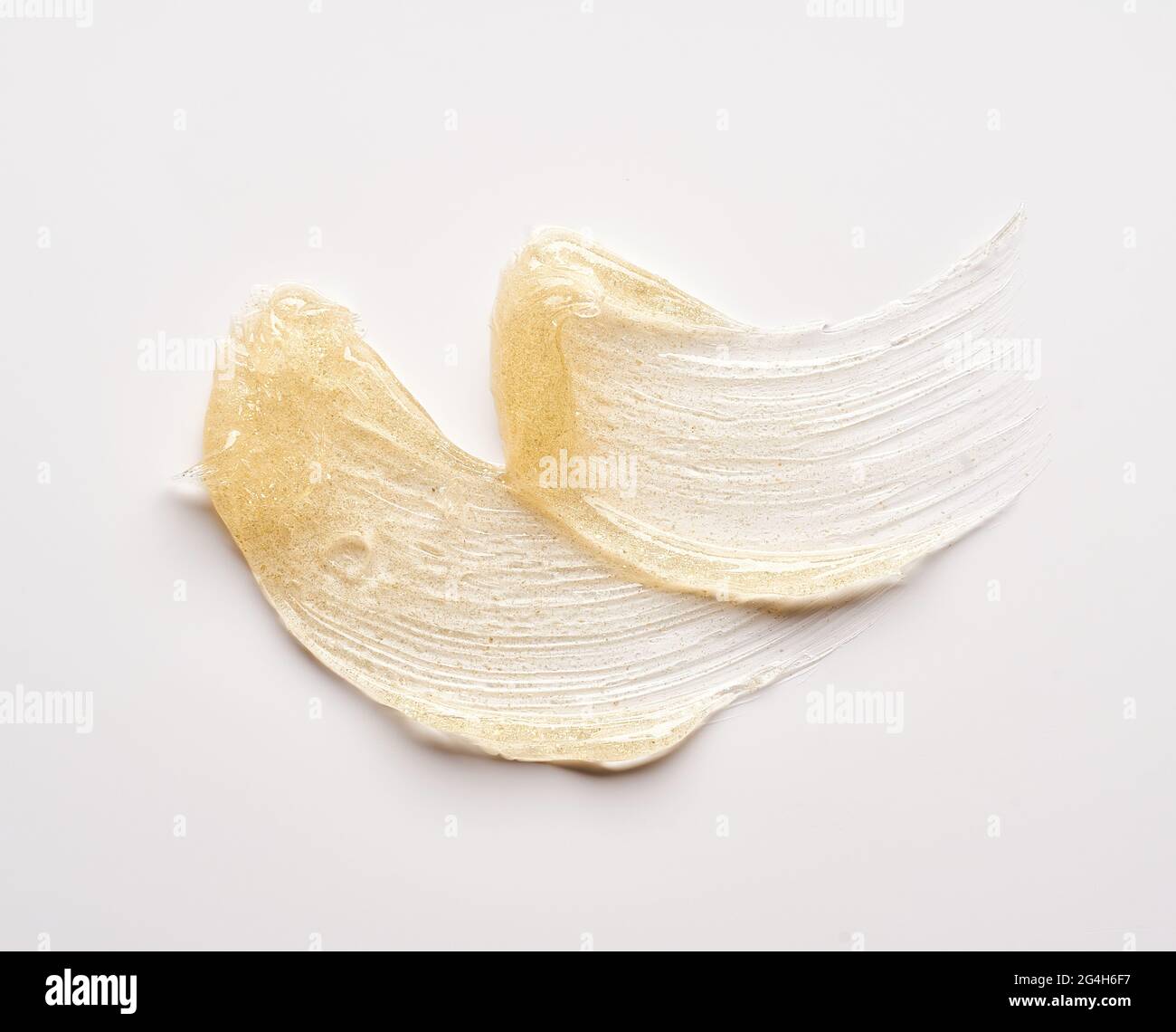 Transparent smear and texture of golden cosmetic gel on a white ...