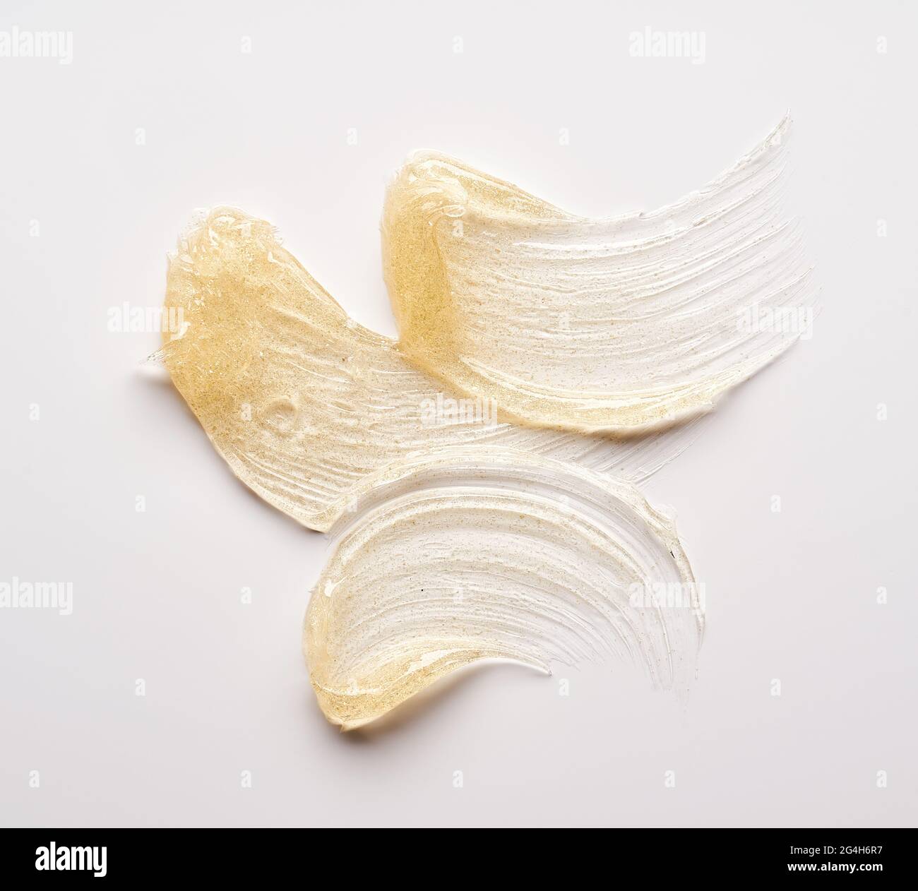 Transparent smear and texture of golden cosmetic gel on a white ...