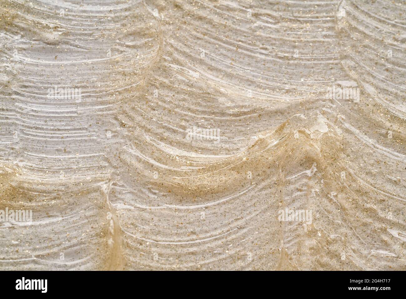 Transparent smear and texture of golden cosmetic gel on a white ...