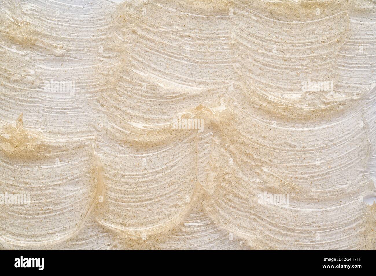 Transparent smear and texture of golden cosmetic gel on a white ...