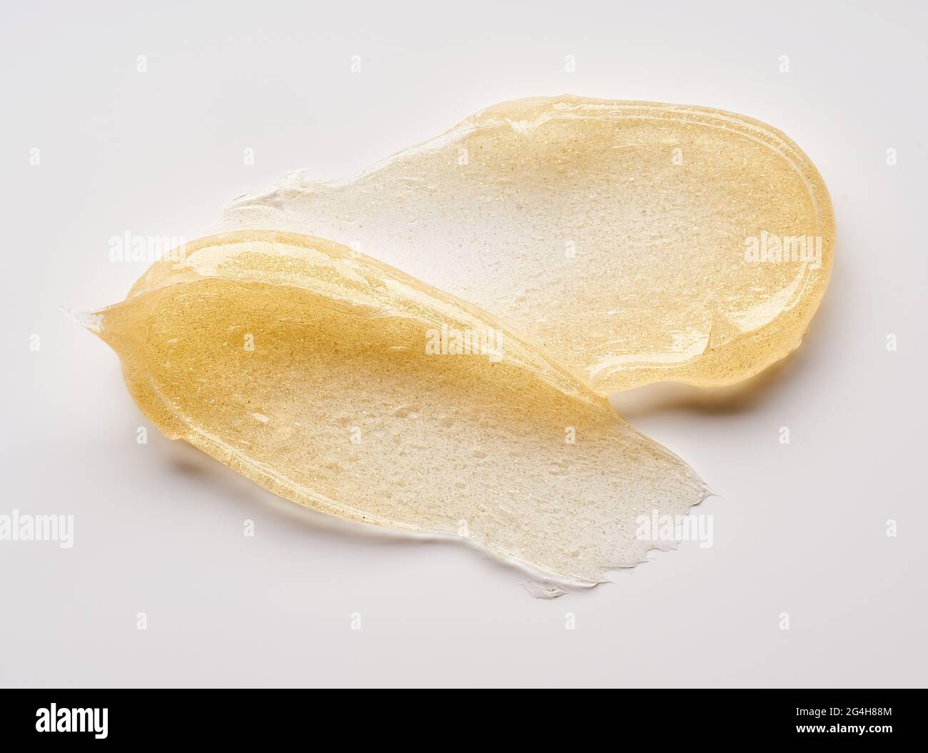 Transparent smear and texture of golden cosmetic gel on a white ...