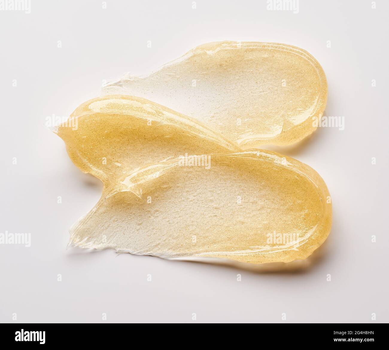 Transparent smear and texture of golden cosmetic gel on a white ...