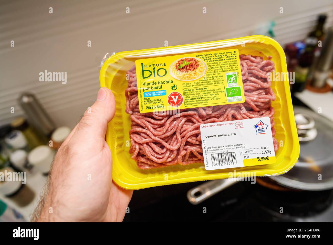 Man hand holding in kitchen package with Nature Bio organic minced beef ...