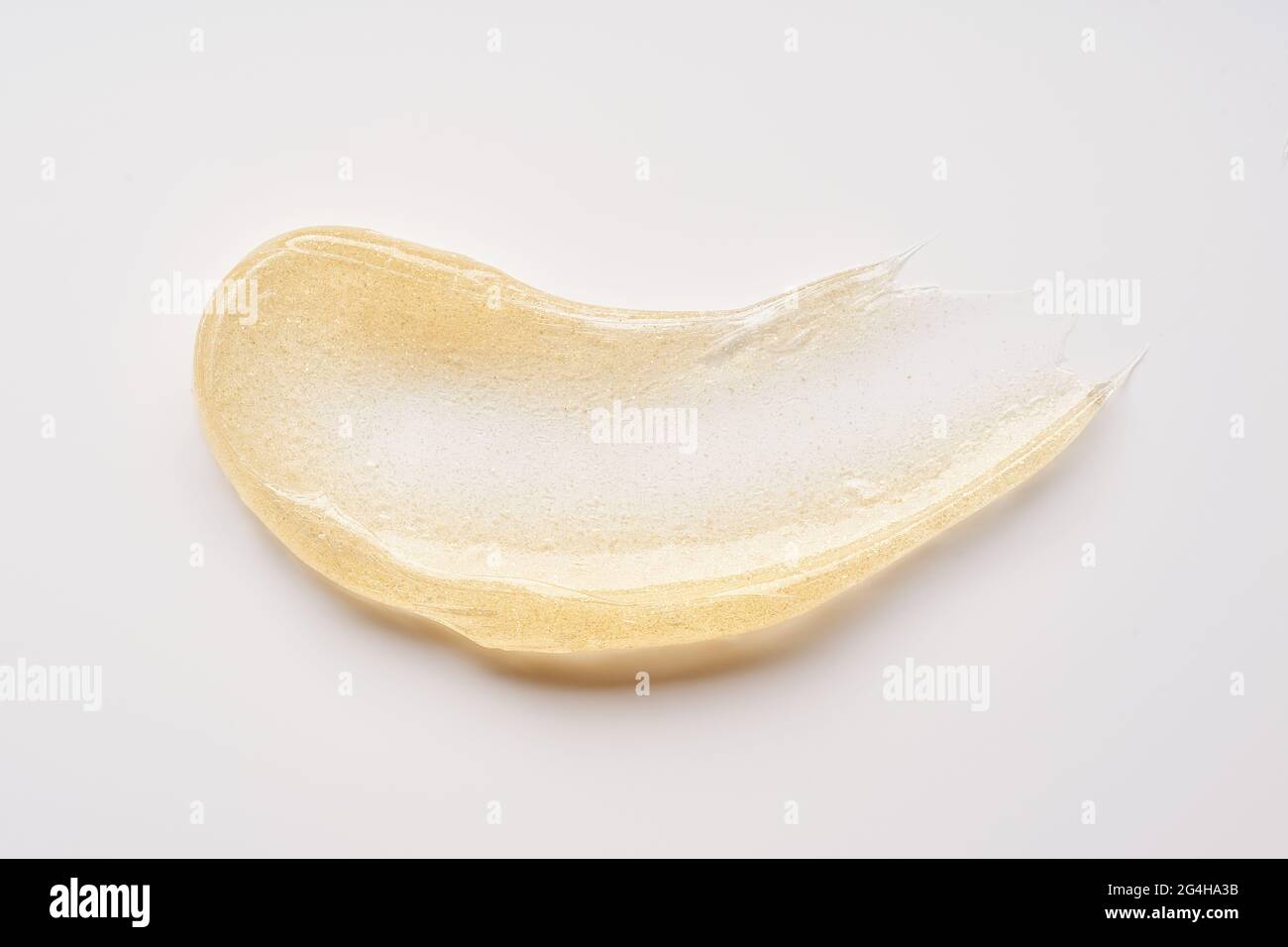 Transparent smear and texture of golden cosmetic gel on a white ...