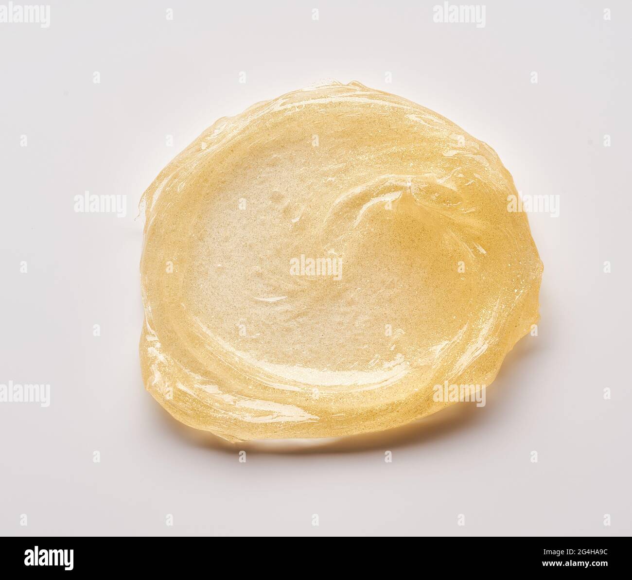 Transparent smear and texture of golden cosmetic gel on a white ...