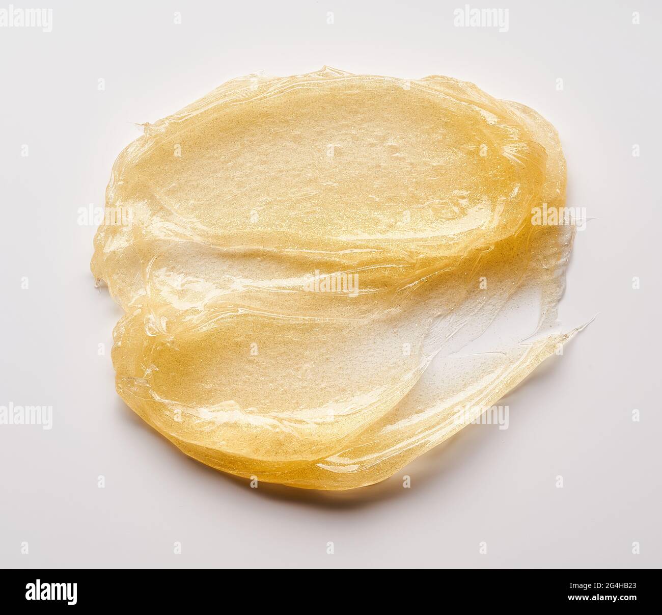 Transparent smear and texture of golden cosmetic gel on a white ...