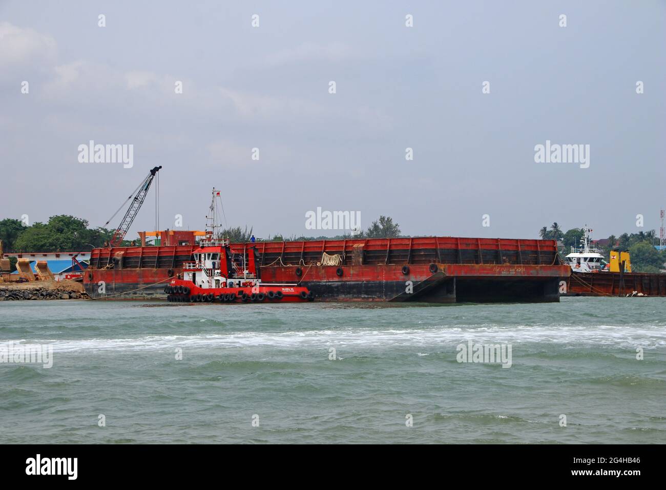 BATAM, INDONESIA - Aug 06, 2019: Large Cargo Barge is on the beach dock ...