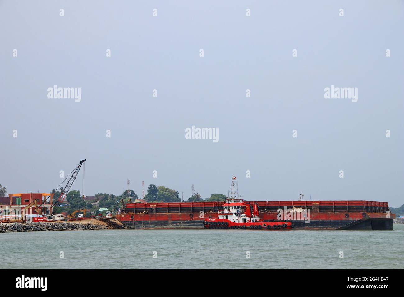 BATAM, INDONESIA - Aug 06, 2019: Large Cargo Barge is on the beach dock ...
