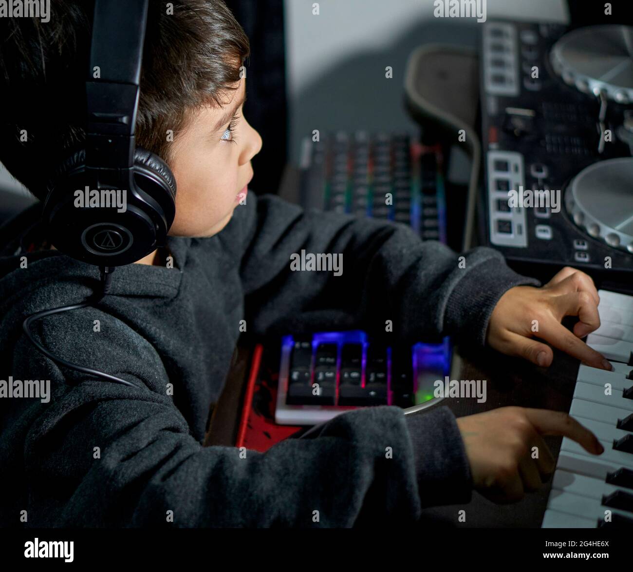 Portrait Of little boy listening to music with headphones and playing ...