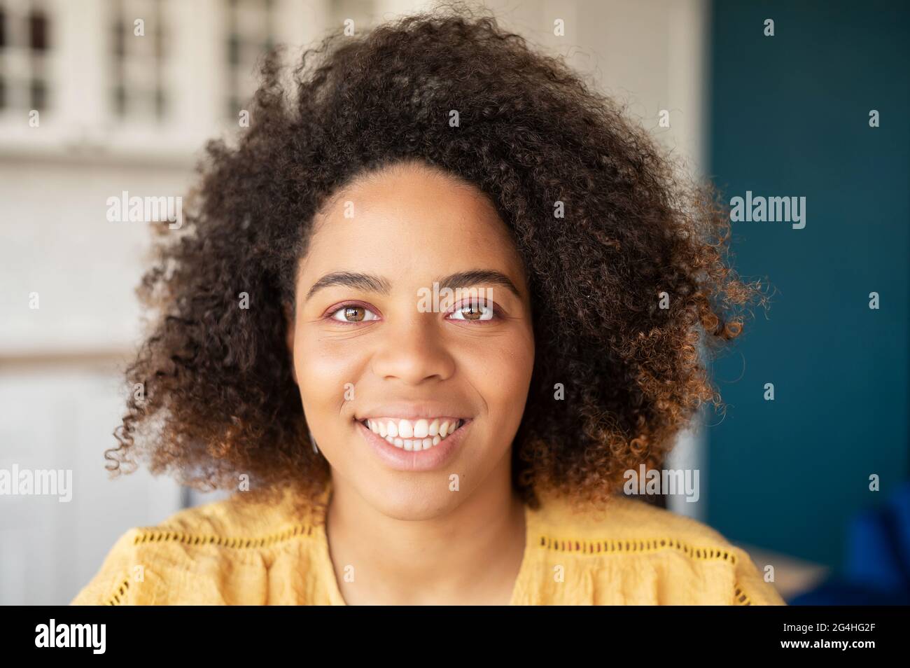 Close-up portrait of attractive dark-skinned young woman with curly ...
