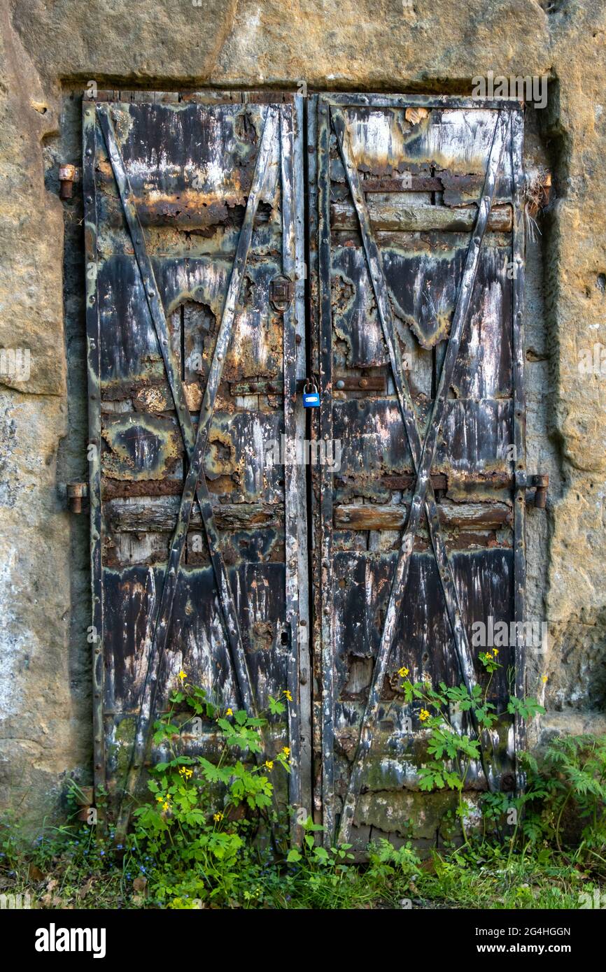 Old damaged door in a room carved into the rock Stock Photo - Alamy