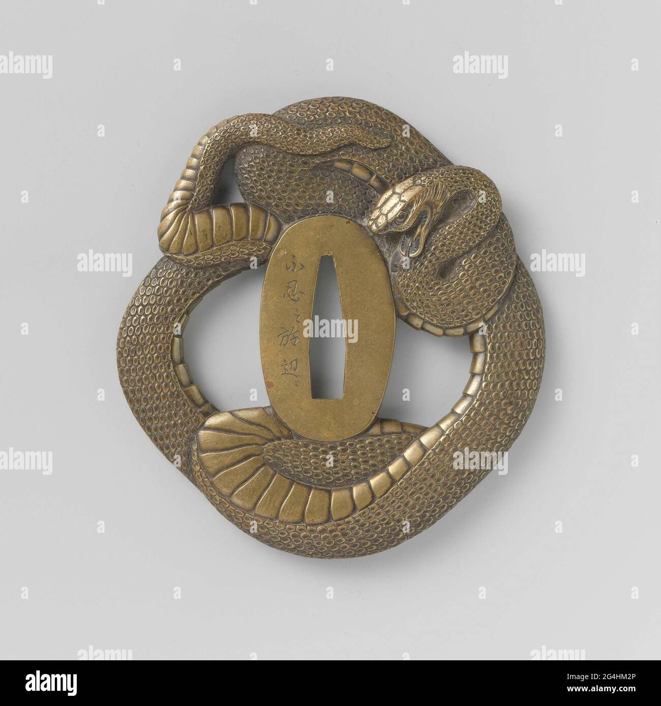 . Tsuba in the form of a snake with opened mouth; tongue and eye in ...