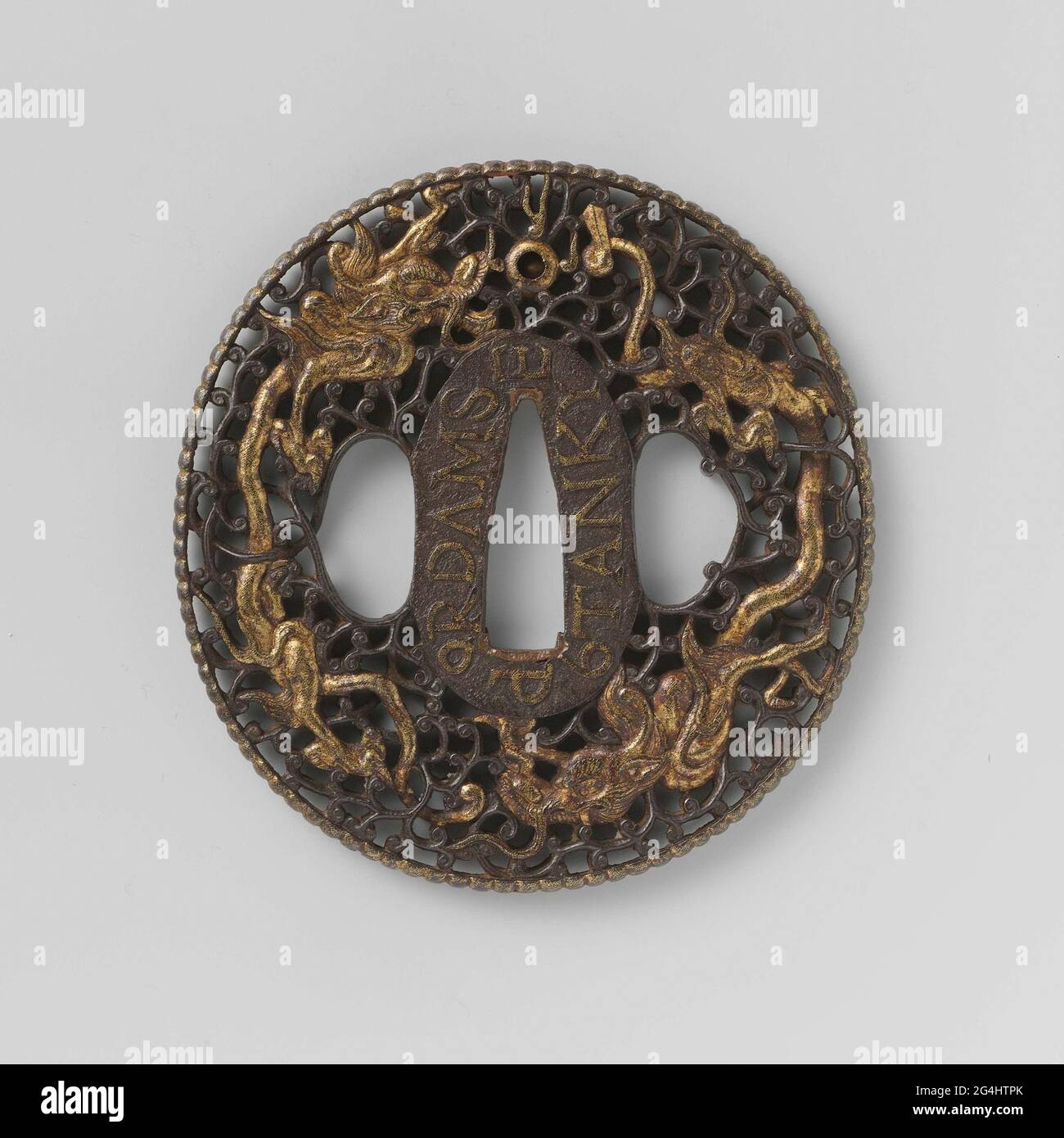 . Oval tsuba with a cut-away decoration of two dragons between stylized ...
