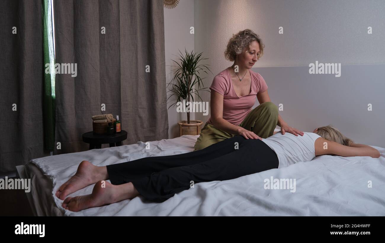A Woman Does A Holistic Back Massage On A Home Bed In The Bedroom Blonde Masseuse On The Couch
