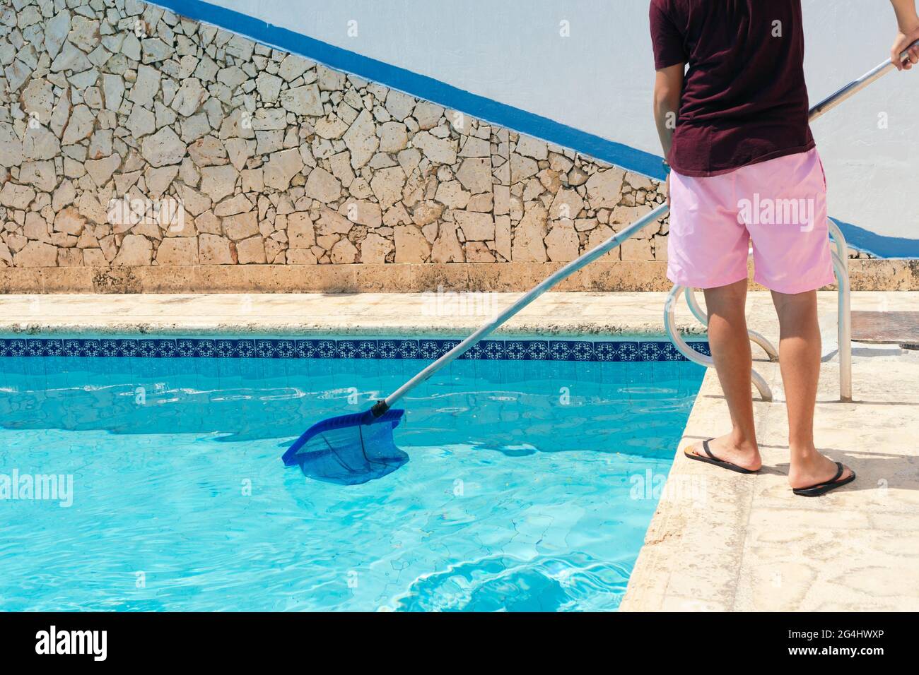 Man cleaning the pool with a net Stock Photo - Alamy