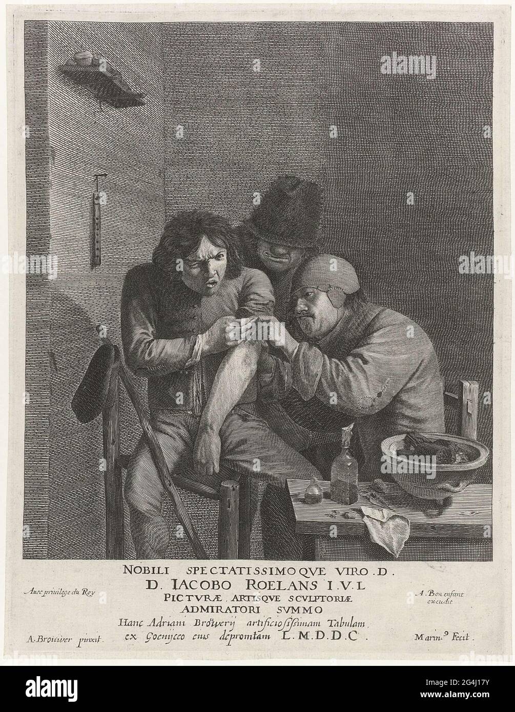 . In an interior, a surgery operates the arm of a young man on a chair ...