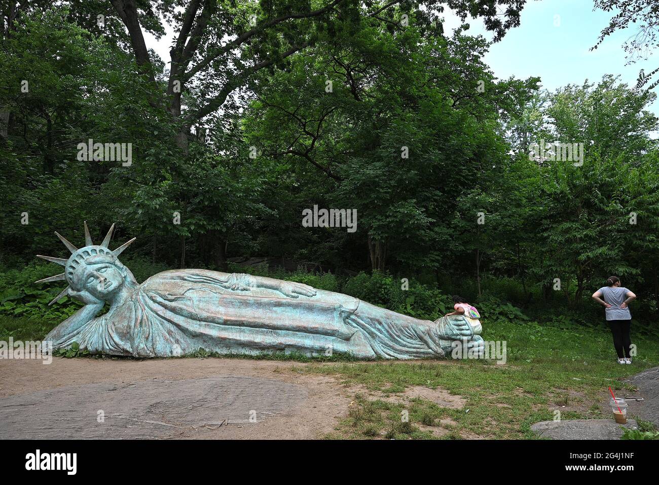 People stand around “Reclining Liberty”, a 25 foot long replica of the Statue of Liberty ...