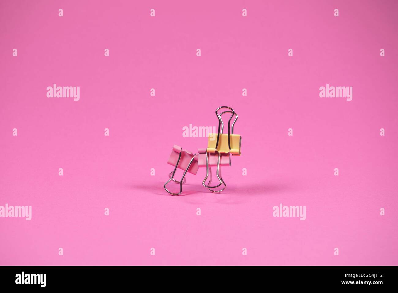 Dog made of steel binder paper clips on trendy pastel pink background ...