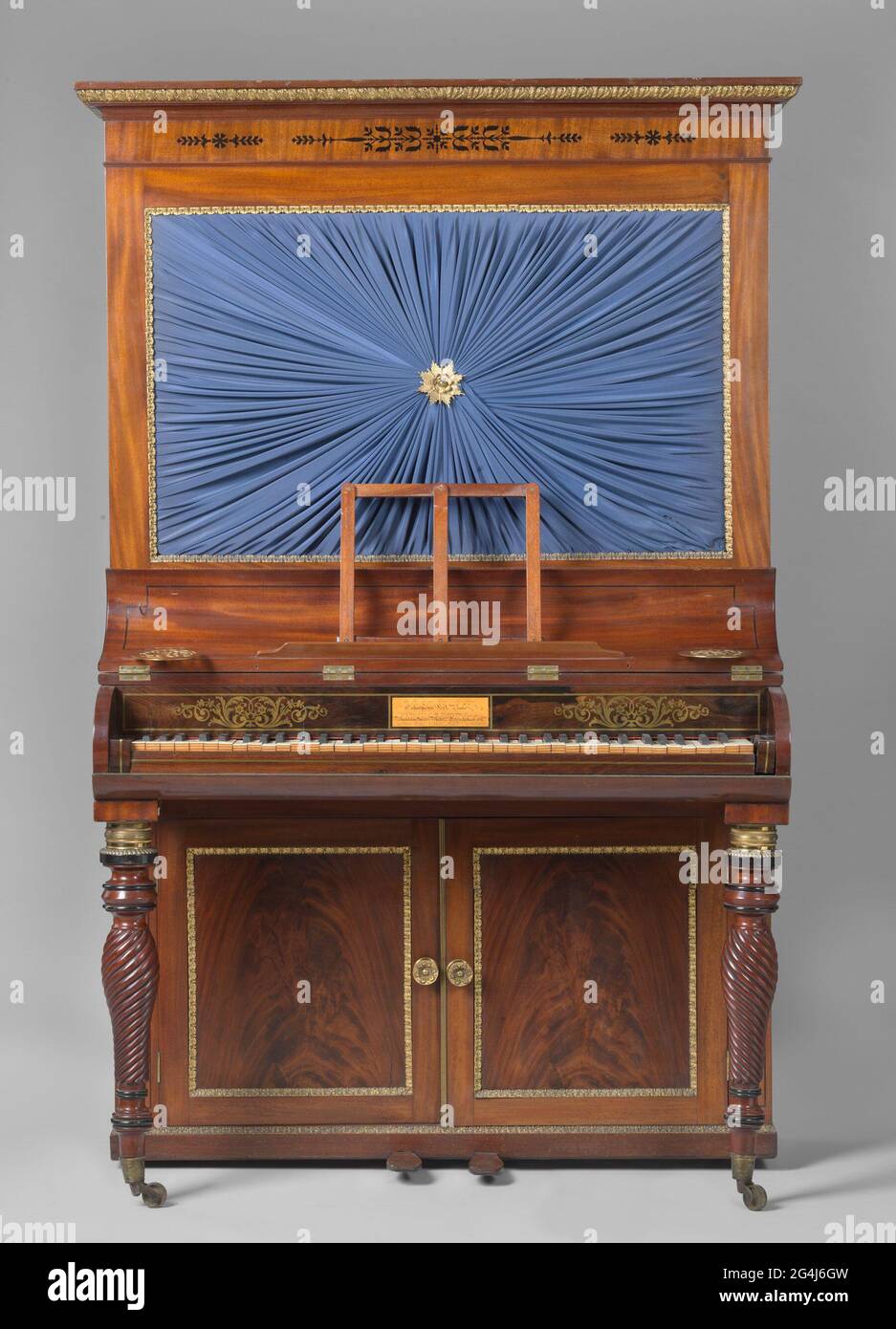 Cabinet piano. Cabinet piano on two helical legs. Copper decorations ...
