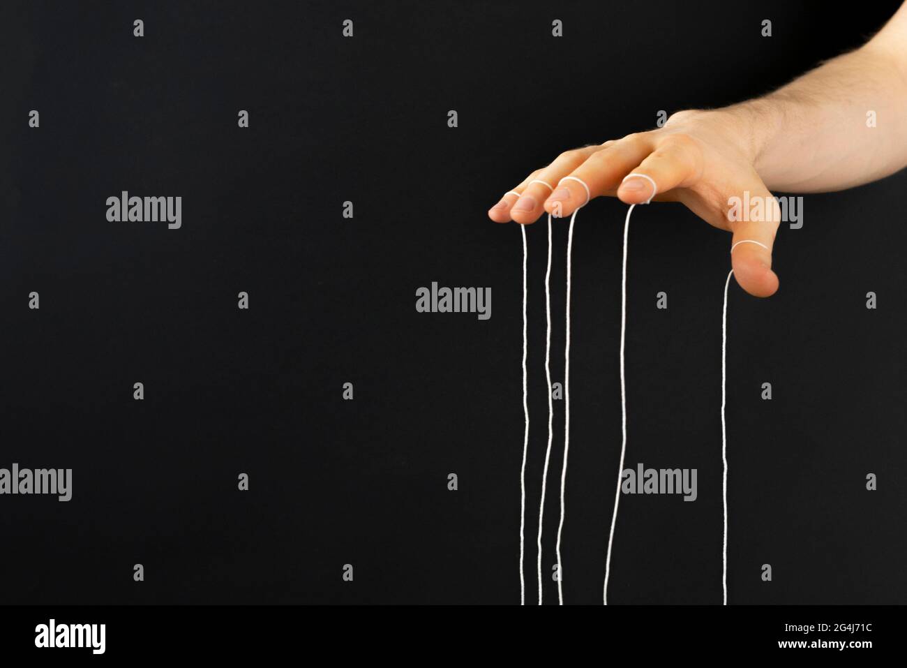 puppeteer's hand with ropes on fingers control the people mind concept ...